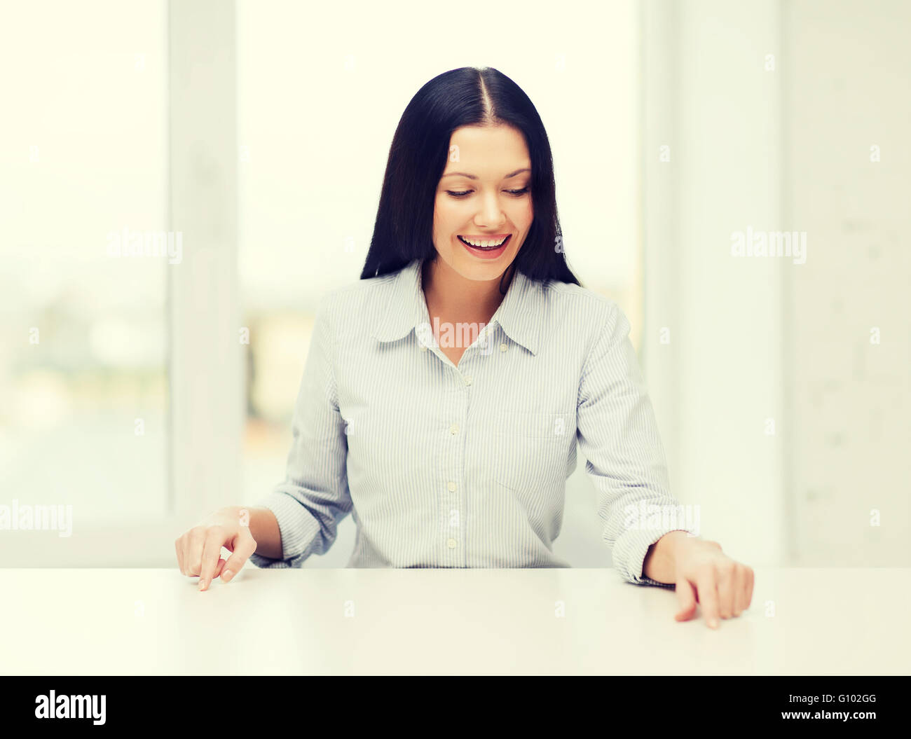 smiling woman pointing to something imaginary Stock Photo - Alamy