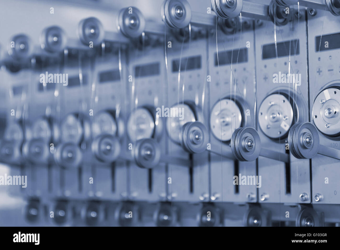 Closeup view of the reel spools on the assembly line in blue hue. All ...
