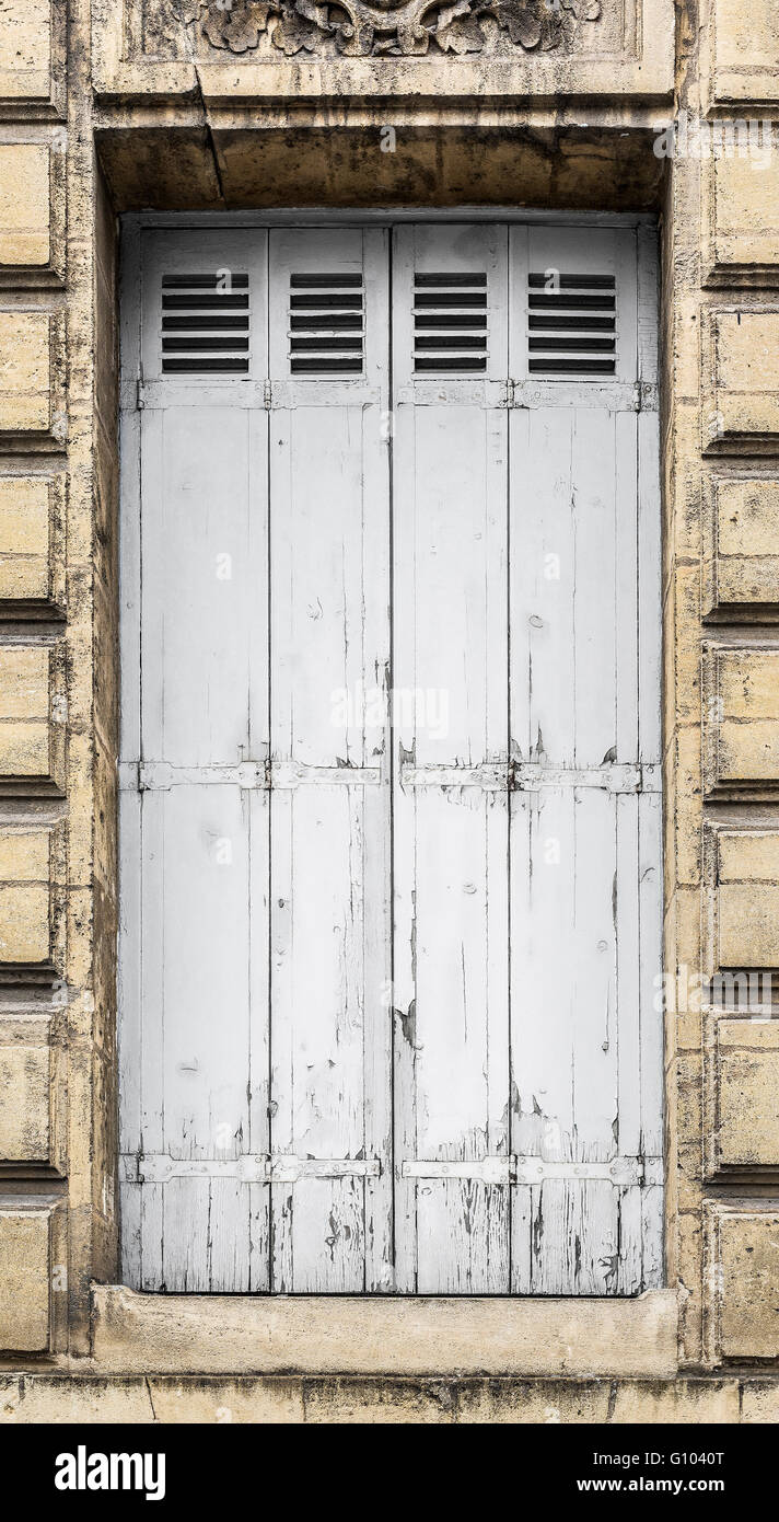 Weathered white wooden window panel with a rusty metal hinges and ...