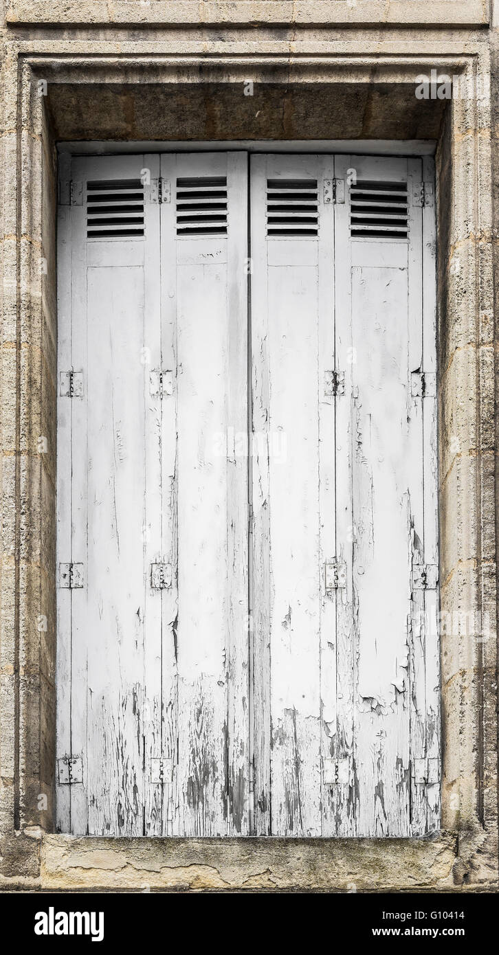 Weathered white wooden window panel with a rusty metal hinges and ...