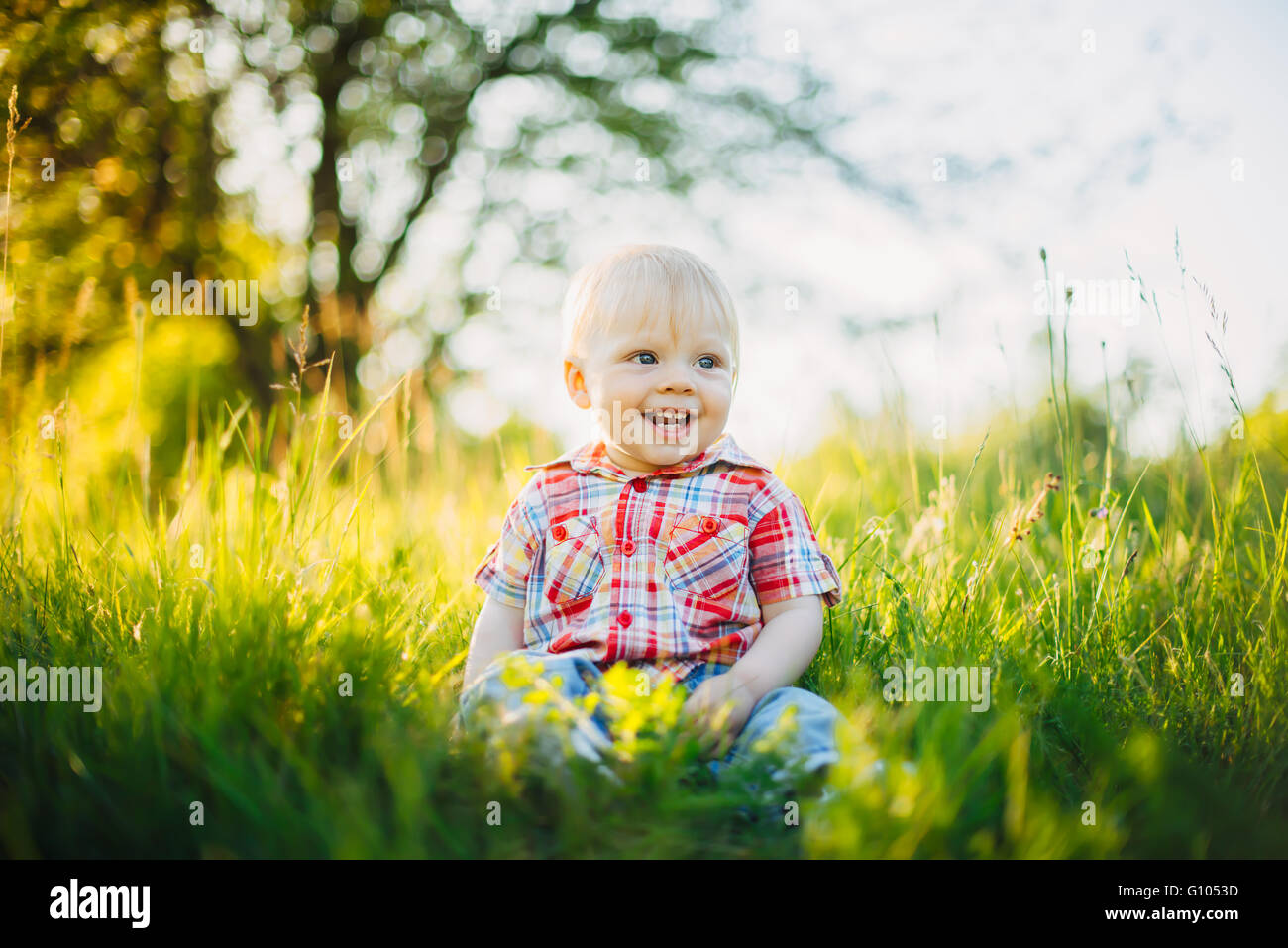 child sitting on the grass Stock Photo - Alamy