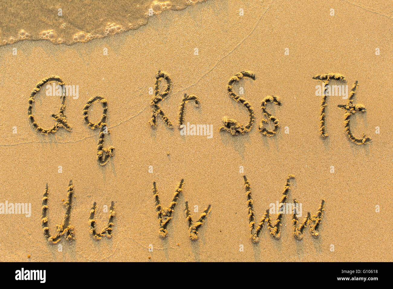 Alphabet written by hand on sandy beach (letters from Q to W Stock ...