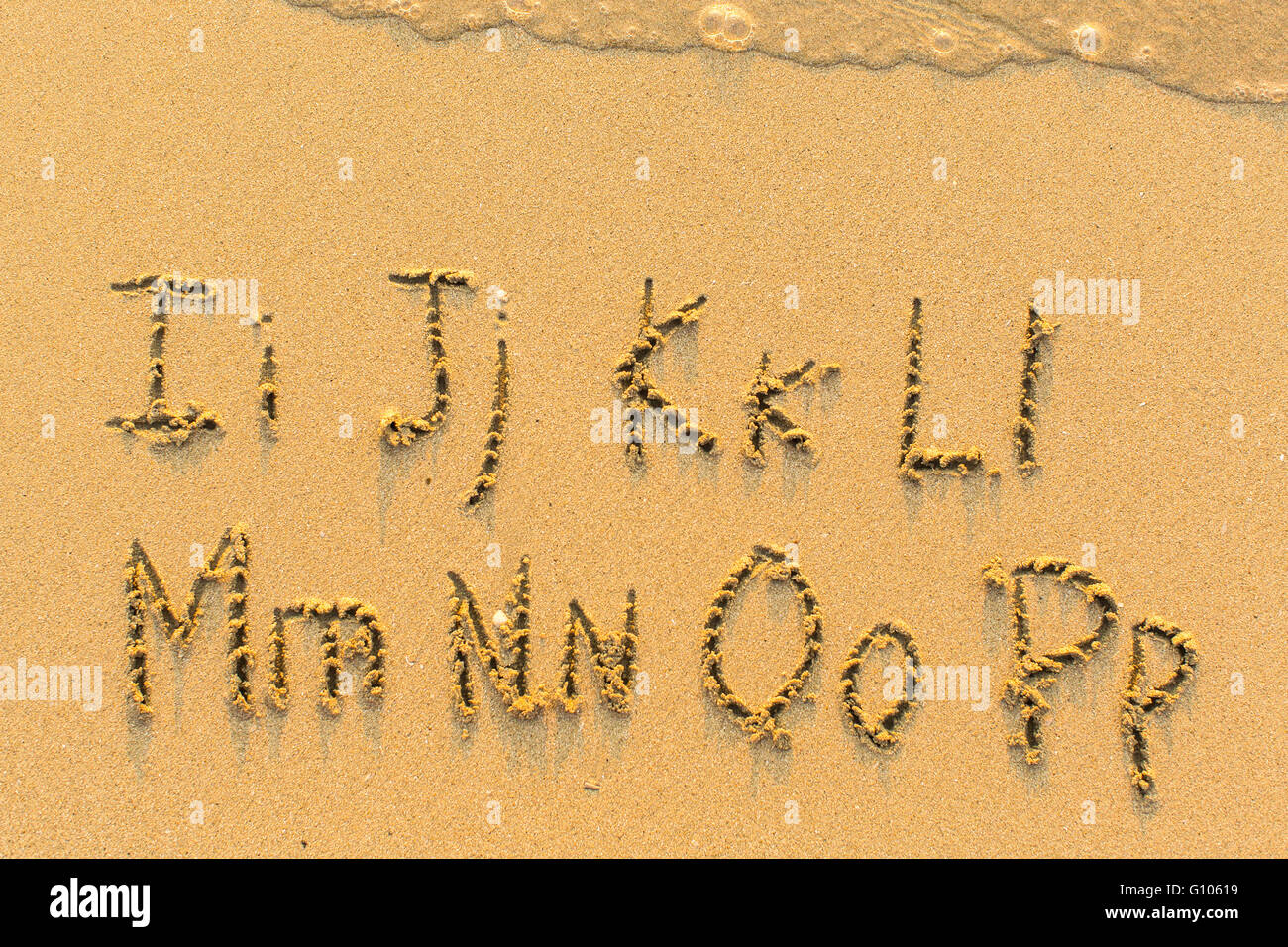 Alphabet written by hand on sandy beach (letters from I to P Stock ...