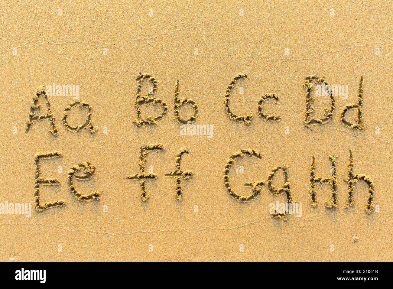 Alphabet written by hand on sandy beach (letters from A to H Stock ...