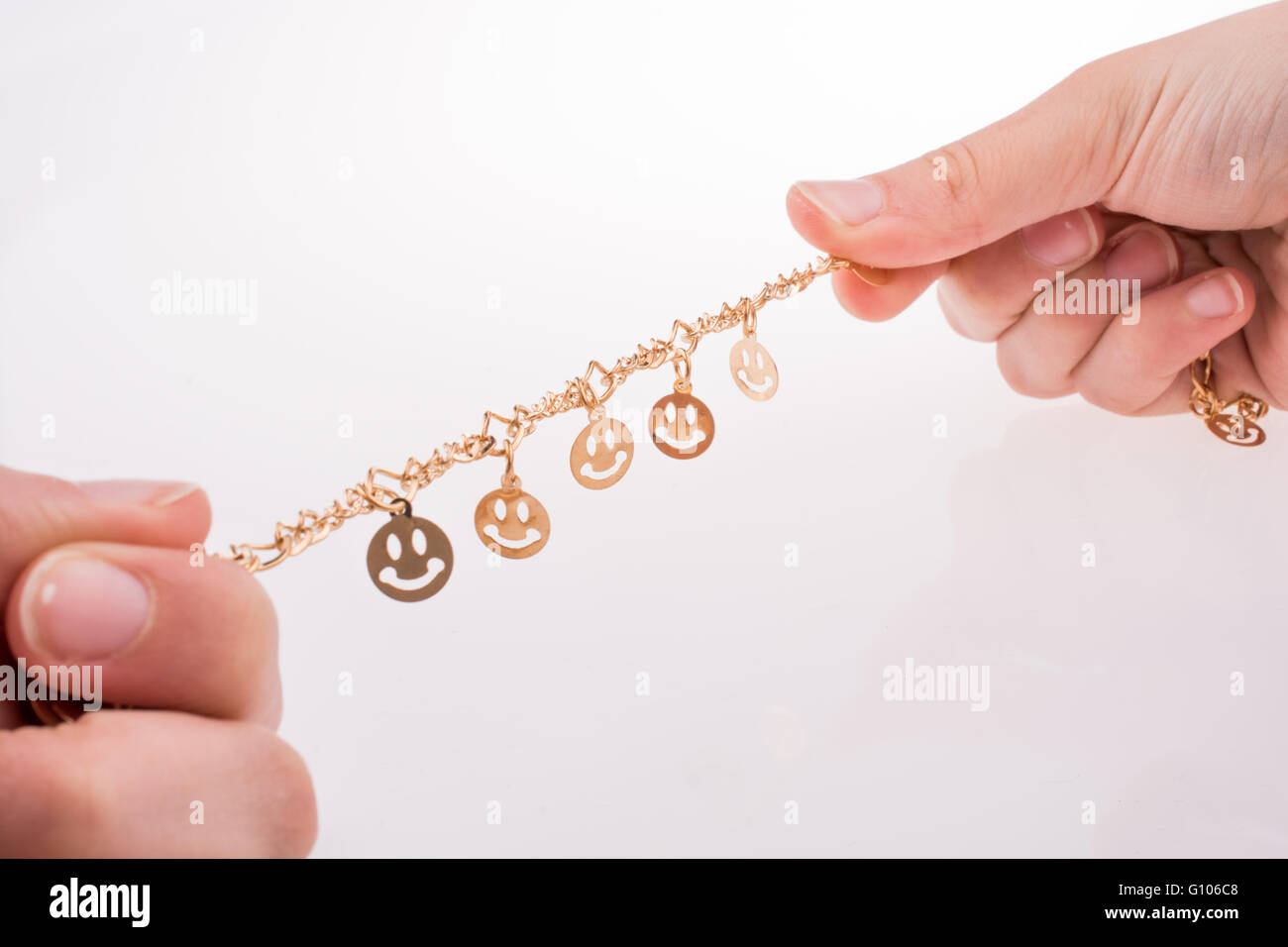 Golden color smileys arrayed on a chain in hand Stock Photo - Alamy