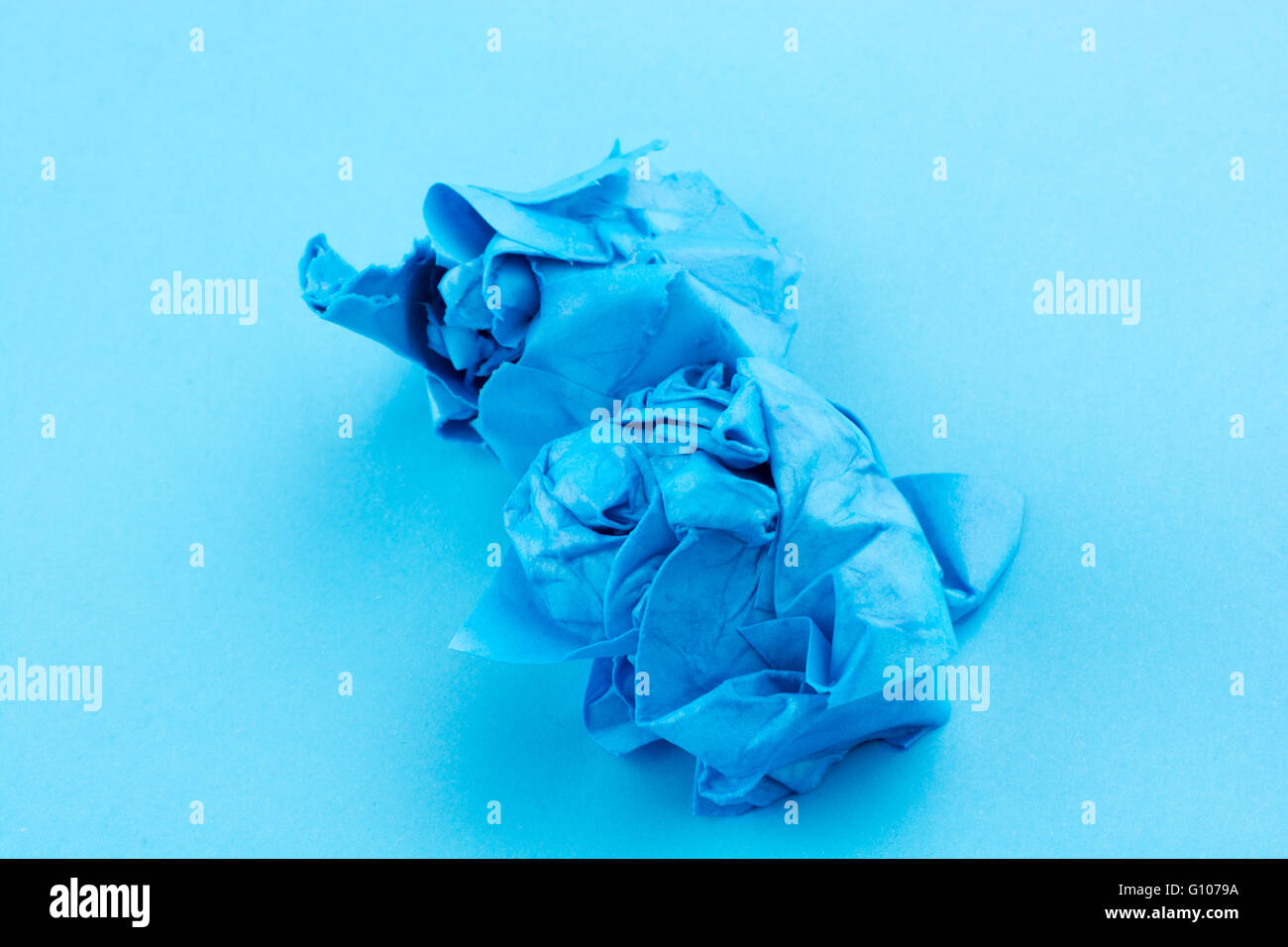 Crumpled paper put in water in blue background Stock Photo - Alamy