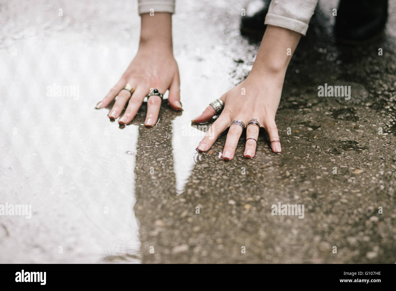 Woman's hands in puddle Stock Photo - Alamy