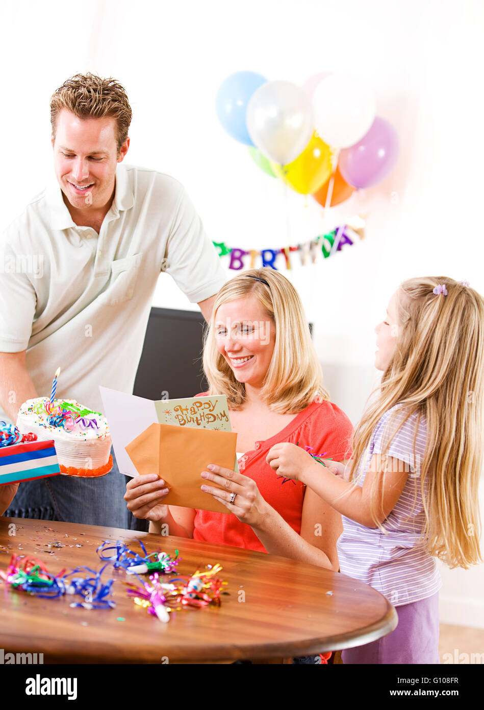 Series with a family celebrating a birthday at home, with balloons and ...