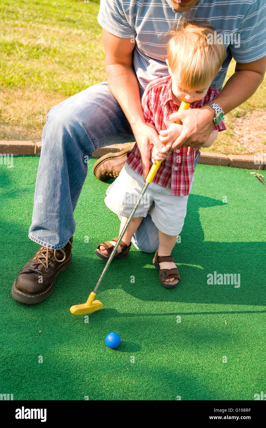 Cute, typical family playing outdoor mini-golf Stock Photo - Alamy