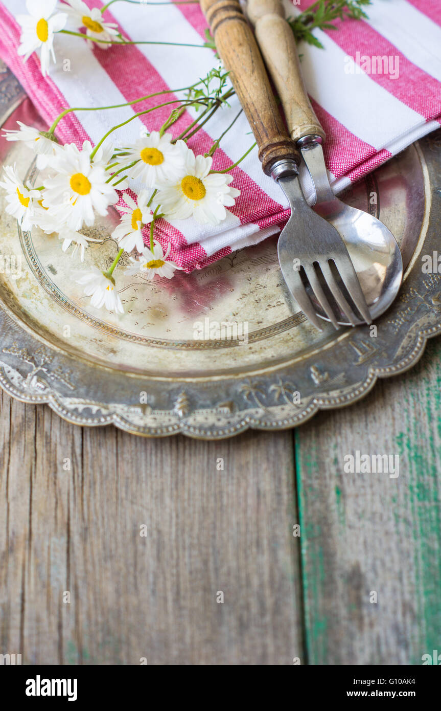 Summertime Table Setting with daisy flowers, napkin and silverware on ...