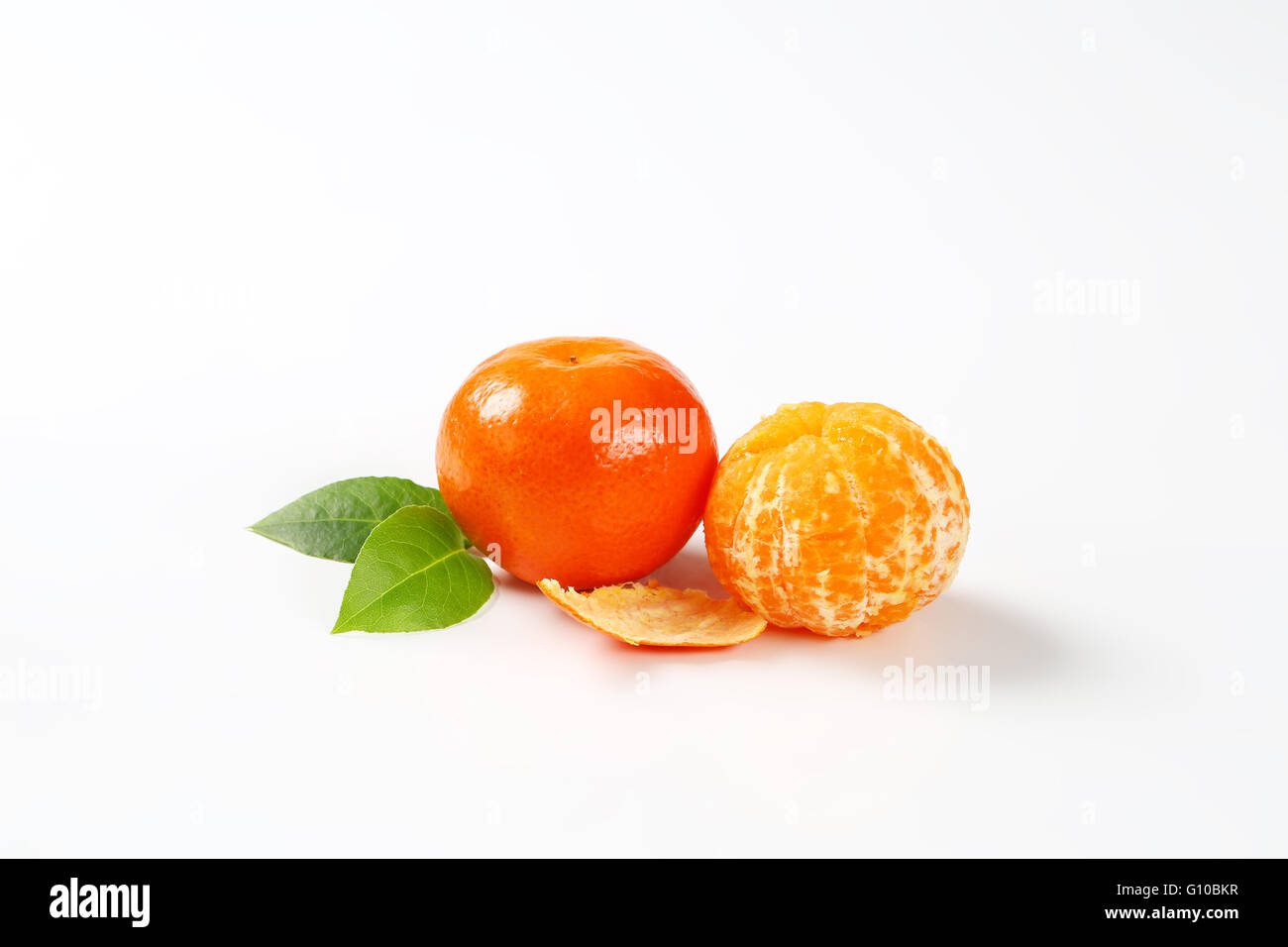two fresh tangerines peeled and unpeeled on white background Stock ...