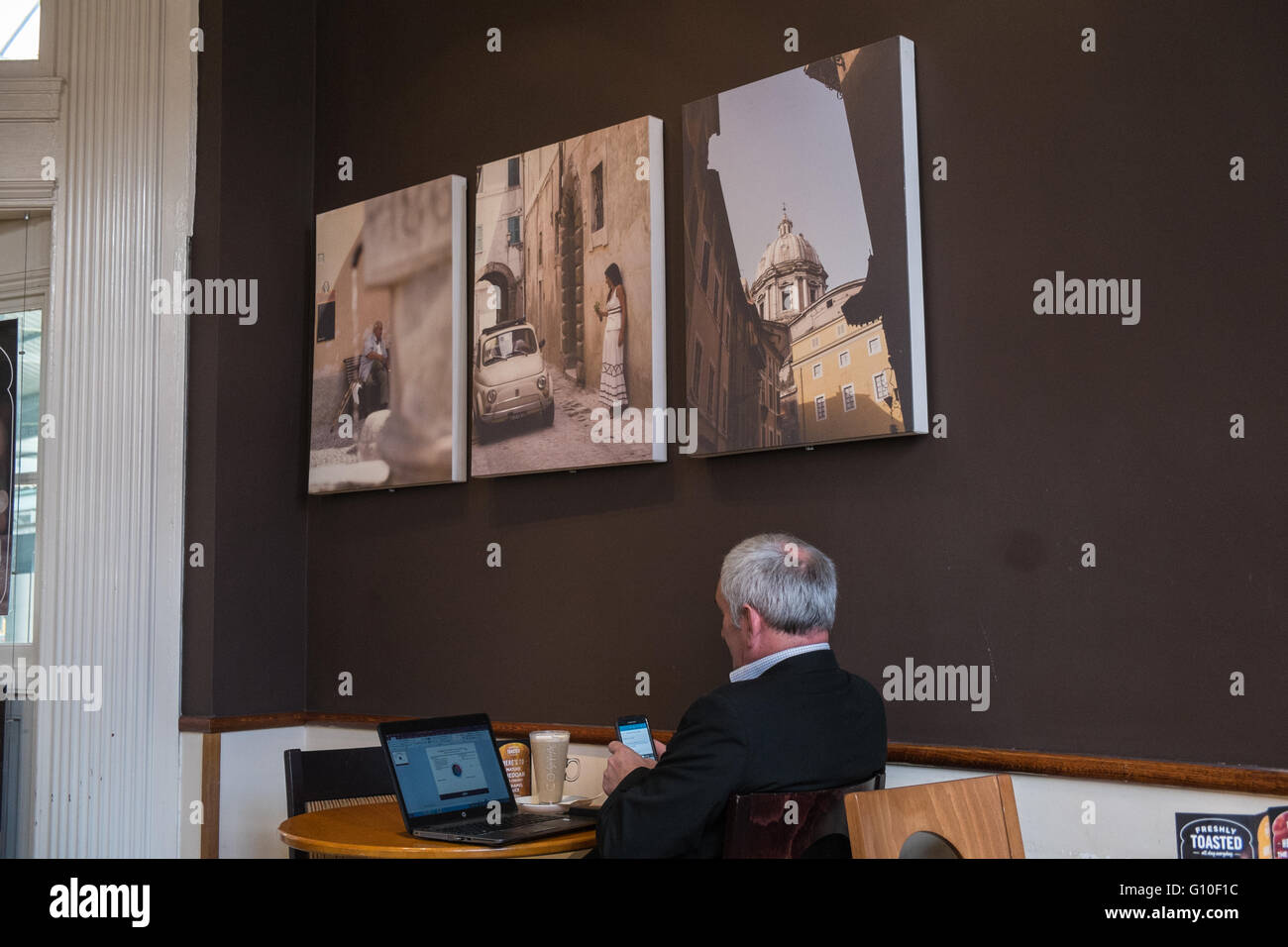 Laptop mobile phone while killing time in coffee shop hi-res stock ...