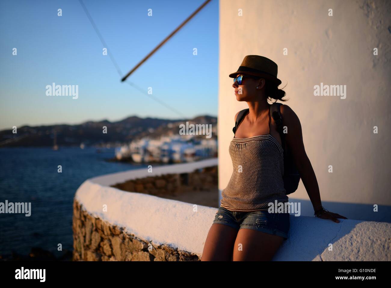 Young woman enjoying sunset from traditional windmills (Kato Milli) in ...