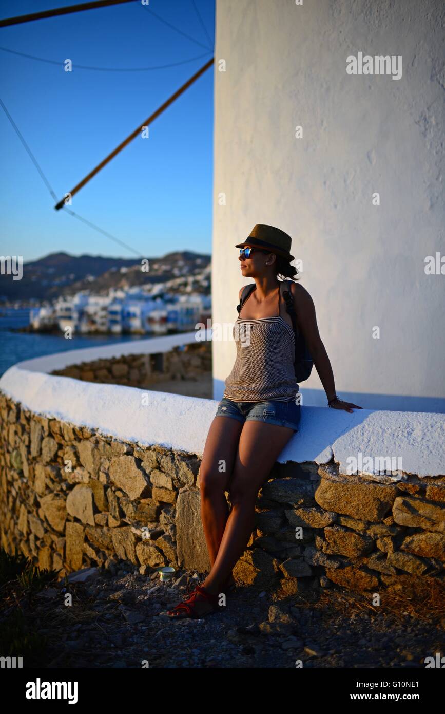 Young woman enjoying sunset from traditional windmills (Kato Milli) in ...