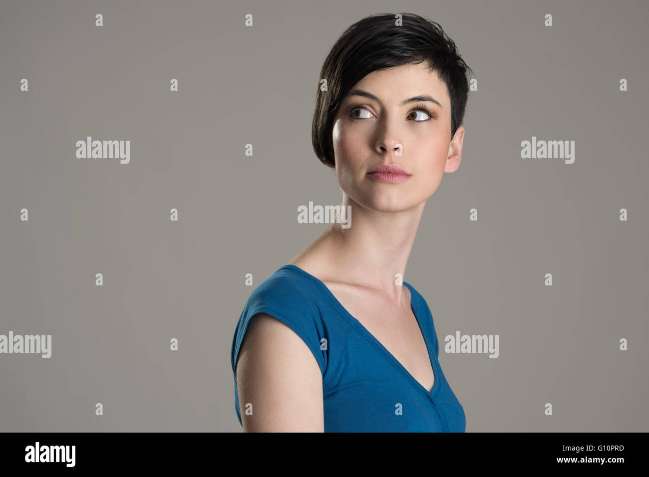 Studio shot of short hair beauty model looking back over the shoulder ...