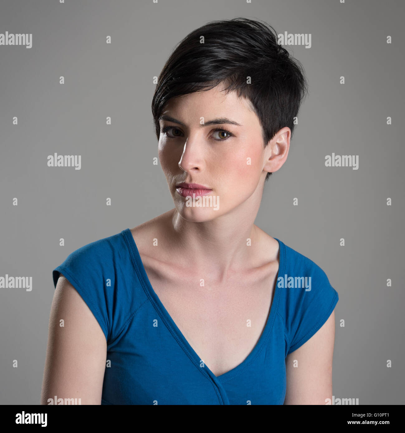 Studio portrait of serious suspicious young woman with questioning look ...
