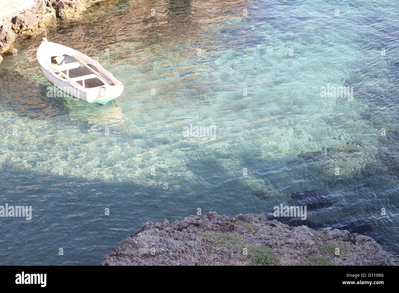 Small white rowing boat in shallow clear sea water Stock Photo - Alamy