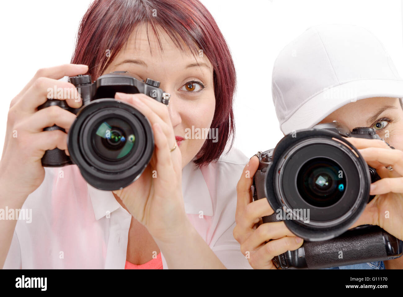Two beautiful young women using a camera on hwhite background Stock ...
