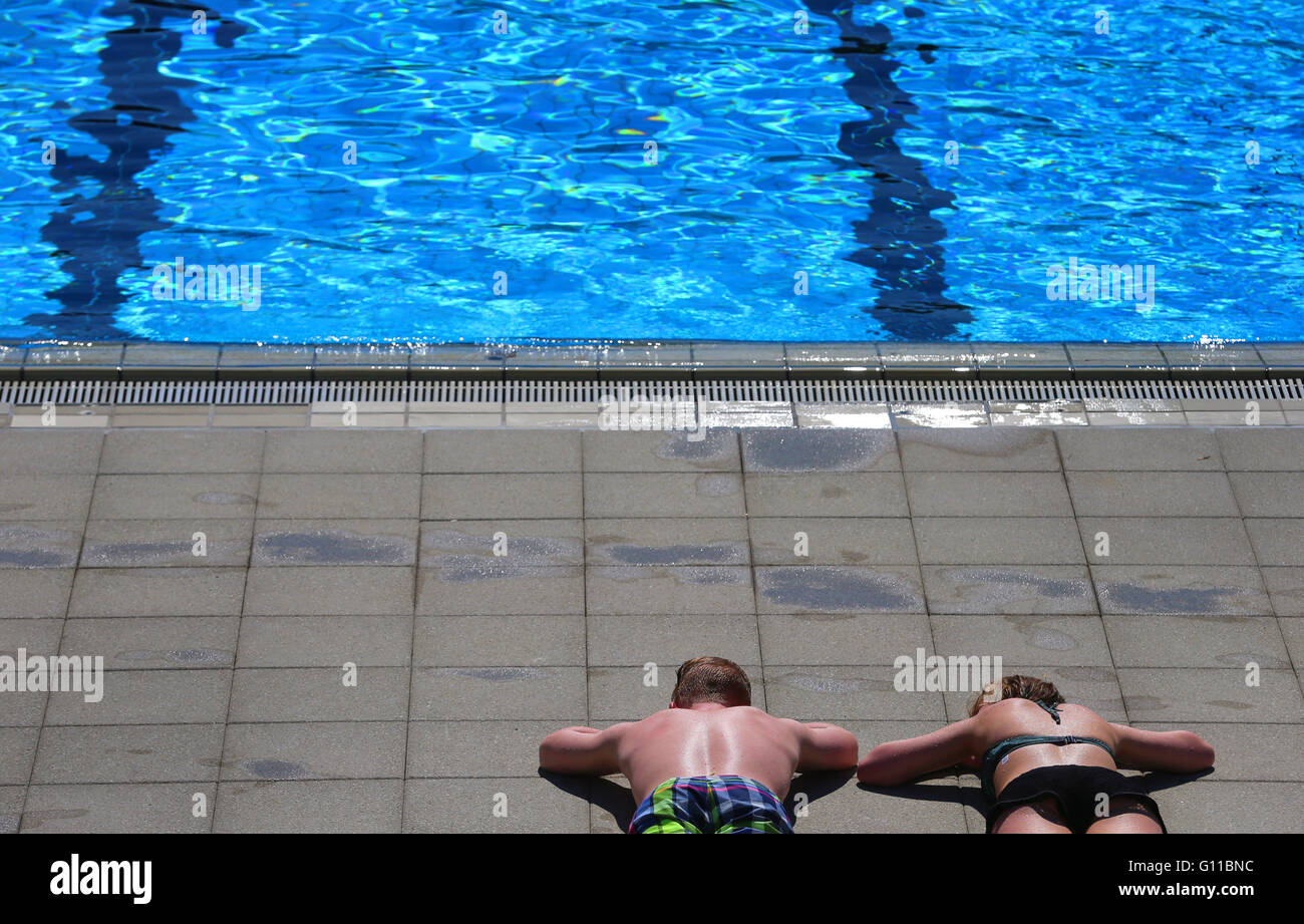 Pool guests lie by the pool to dry off at the outdoor pool in Landsberg ...