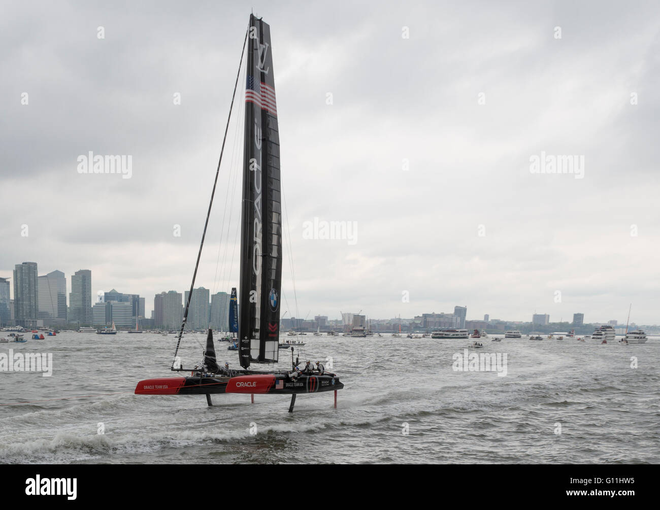 Oracle USA team sailing yacht foiling as they are being towed past ...