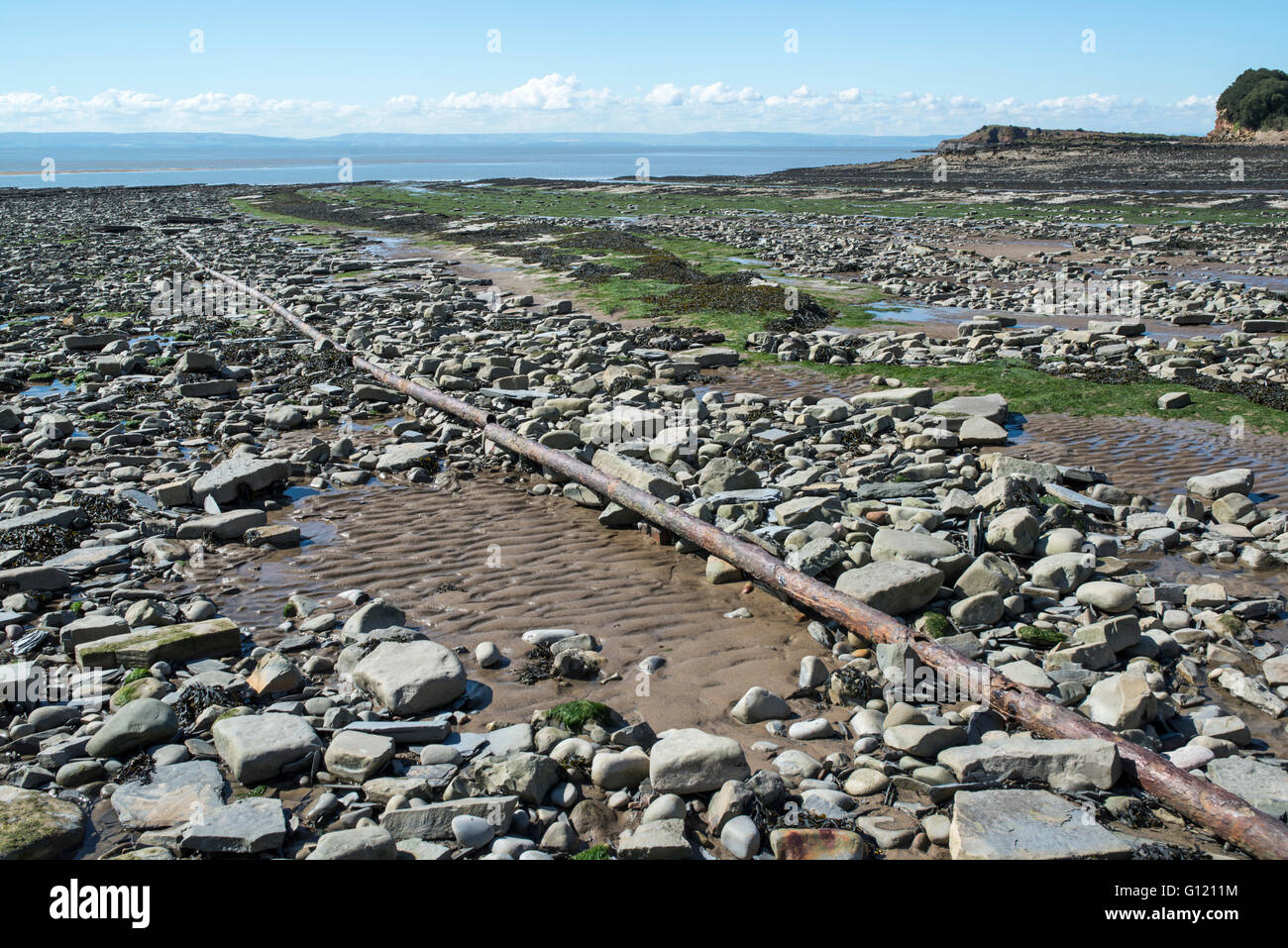 Disused discharge pipe crossing a sand and pebble beach Stock Photo - Alamy