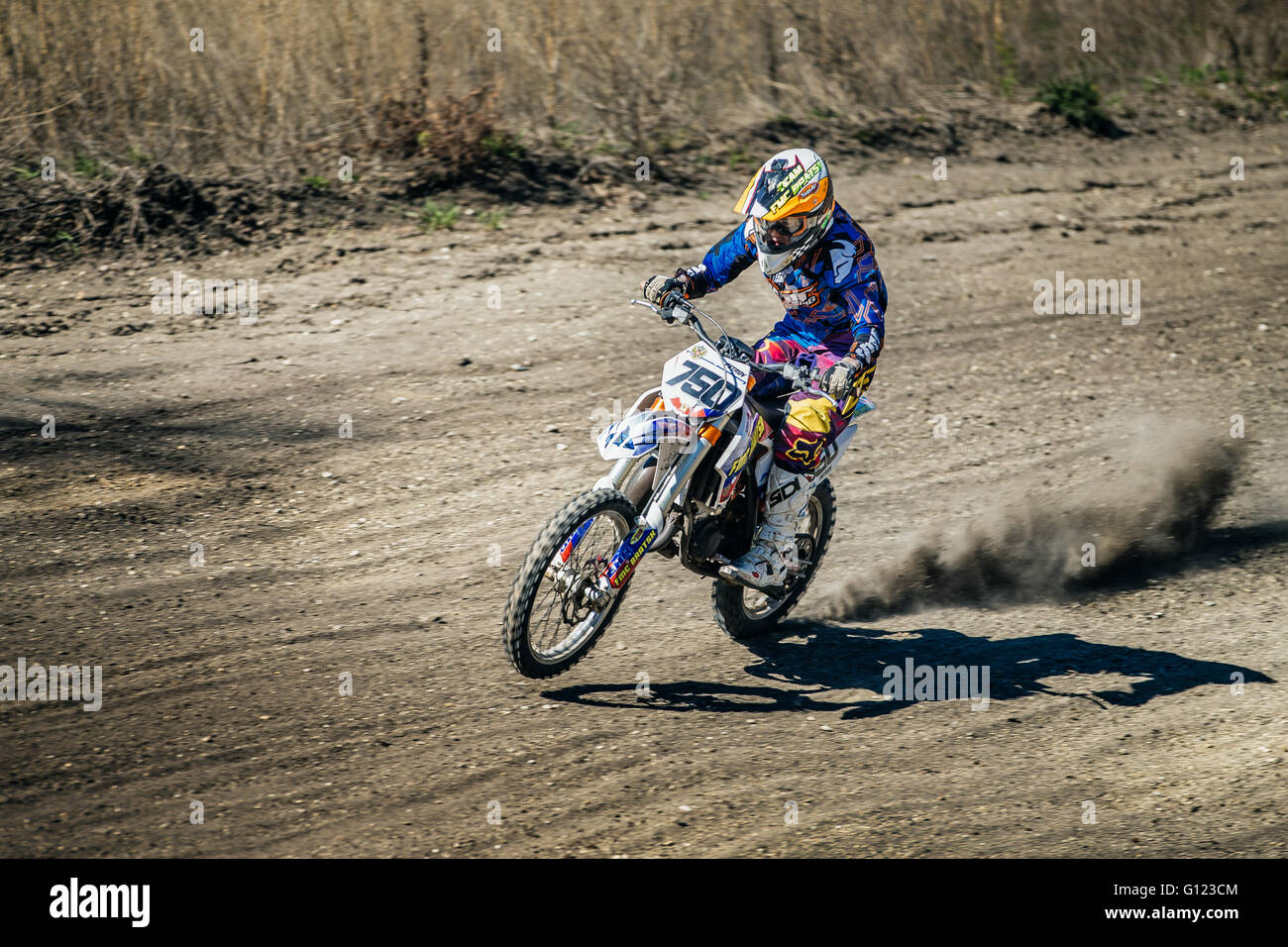 racer on a motorcycle rides on rear wheel during Cup of Urals motocross ...
