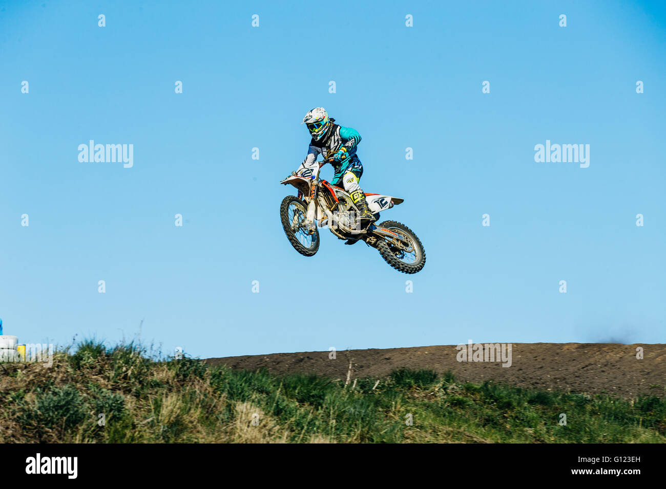 racer motorcycle jump from mountain on a blue sky background during Cup ...