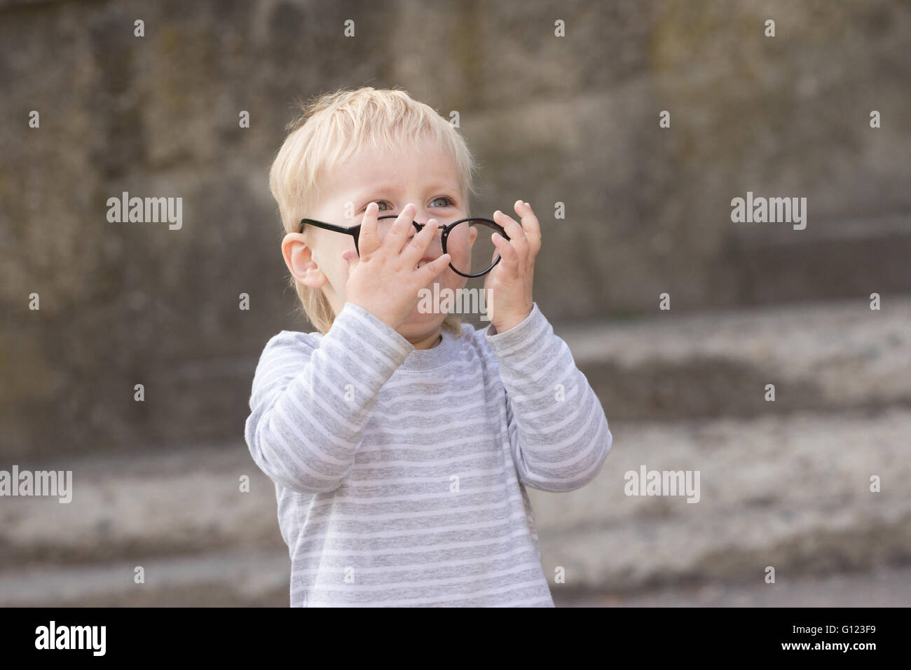 Happy child with falling down glasses, outdoors Stock Photo - Alamy