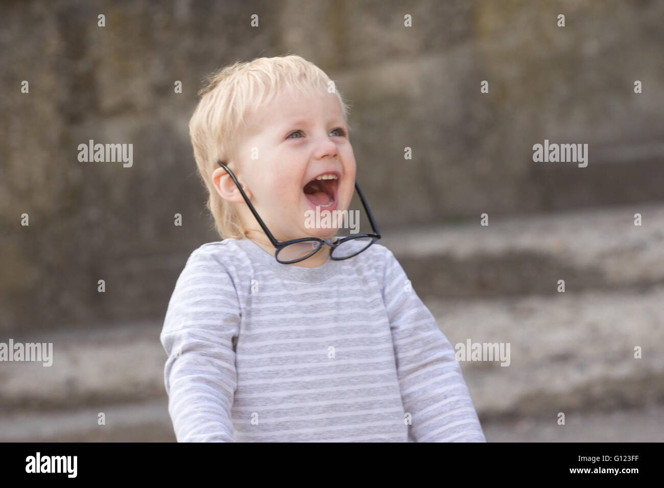 Happy child with falling down glasses, outdoors Stock Photo - Alamy