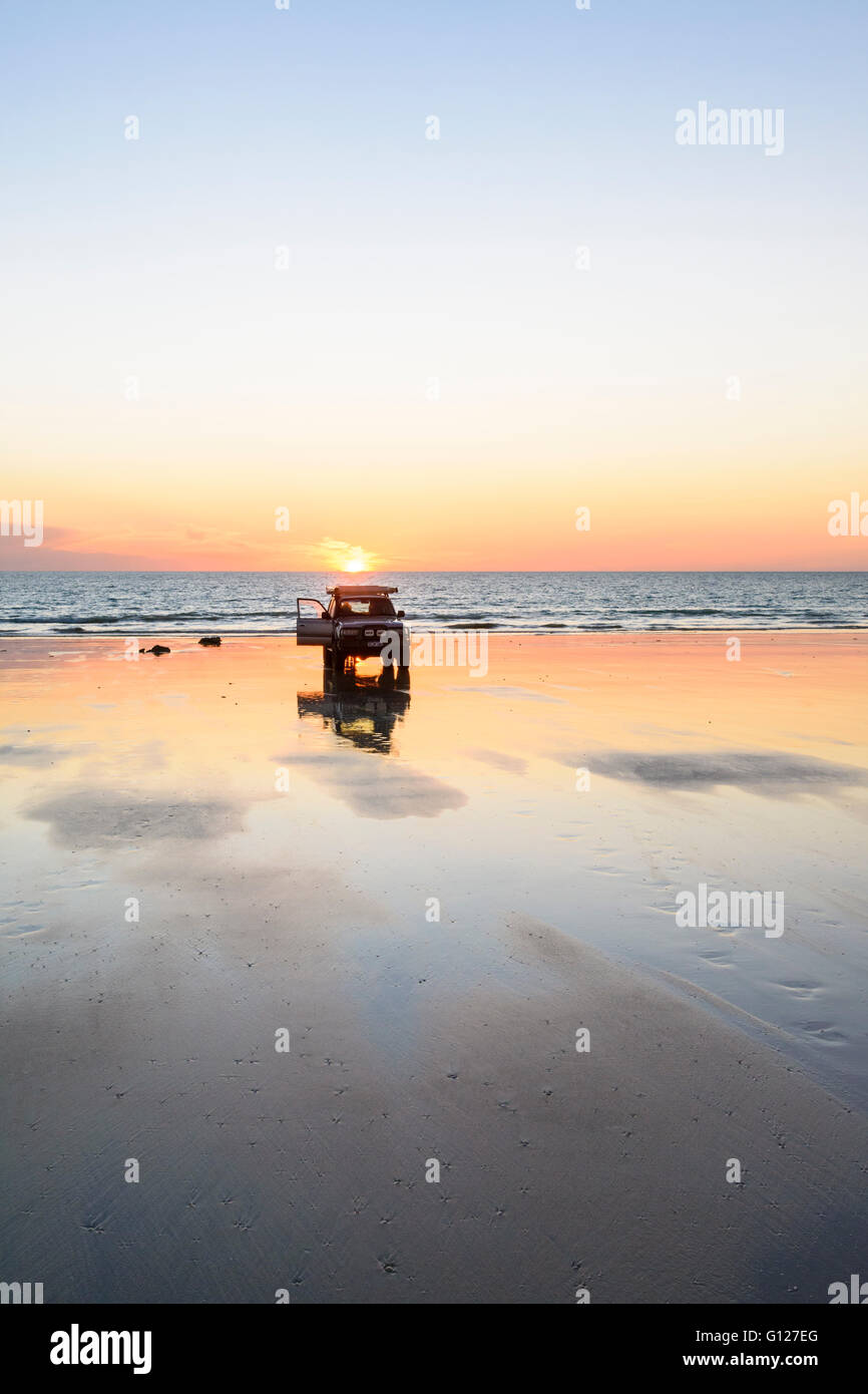 An Australian scene of a four wheel drive parked on the beach at sunset ...