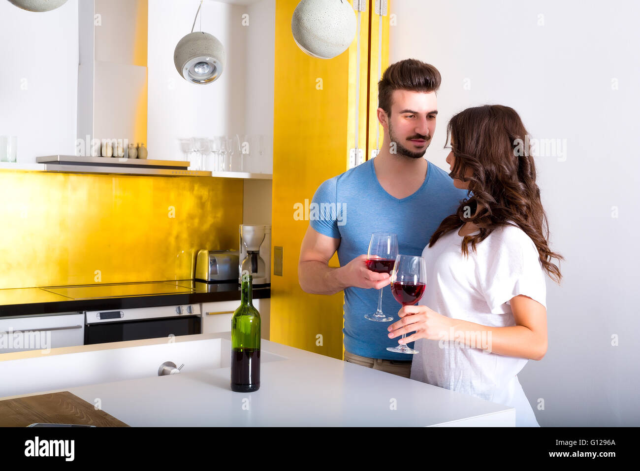 A young couple drinking wine in the kitchen at home Stock Photo - Alamy