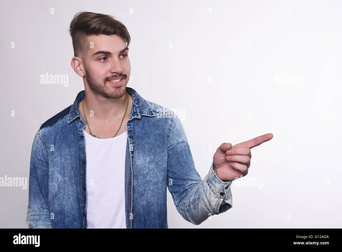 Portrait of young handsome man pointing to white background Stock Photo ...
