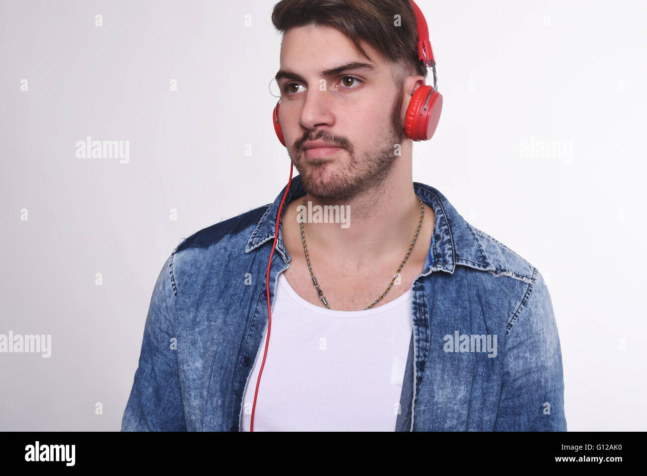 Portrait of young handsome man listening to music. Isolated white ...