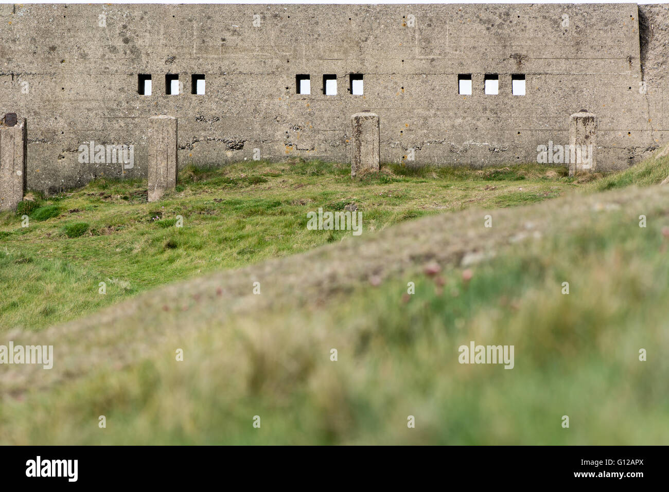 Concrete wall with ports for gunfire. Section of ruined fort on the ...