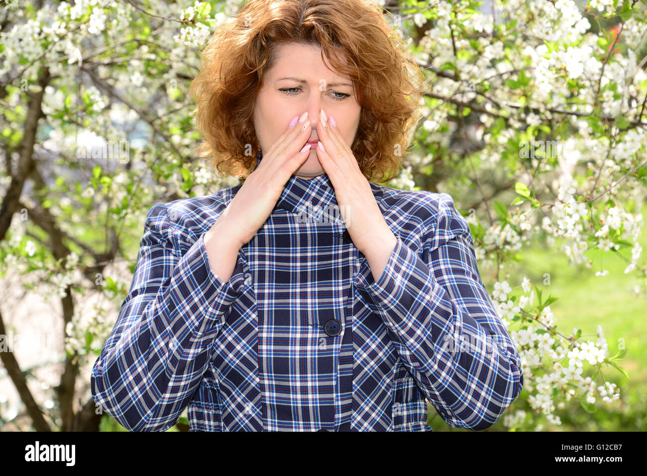 Woman suffering from allergic rhinitis in a lush park Stock Photo - Alamy