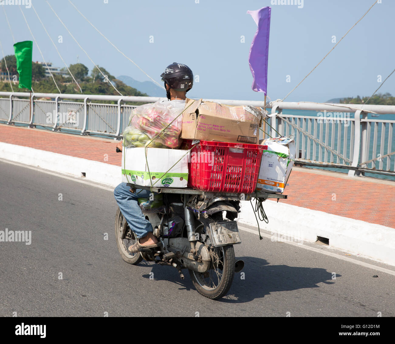 Man on a motorbike loaded up with boxes in Vietnam Stock Photo - Alamy