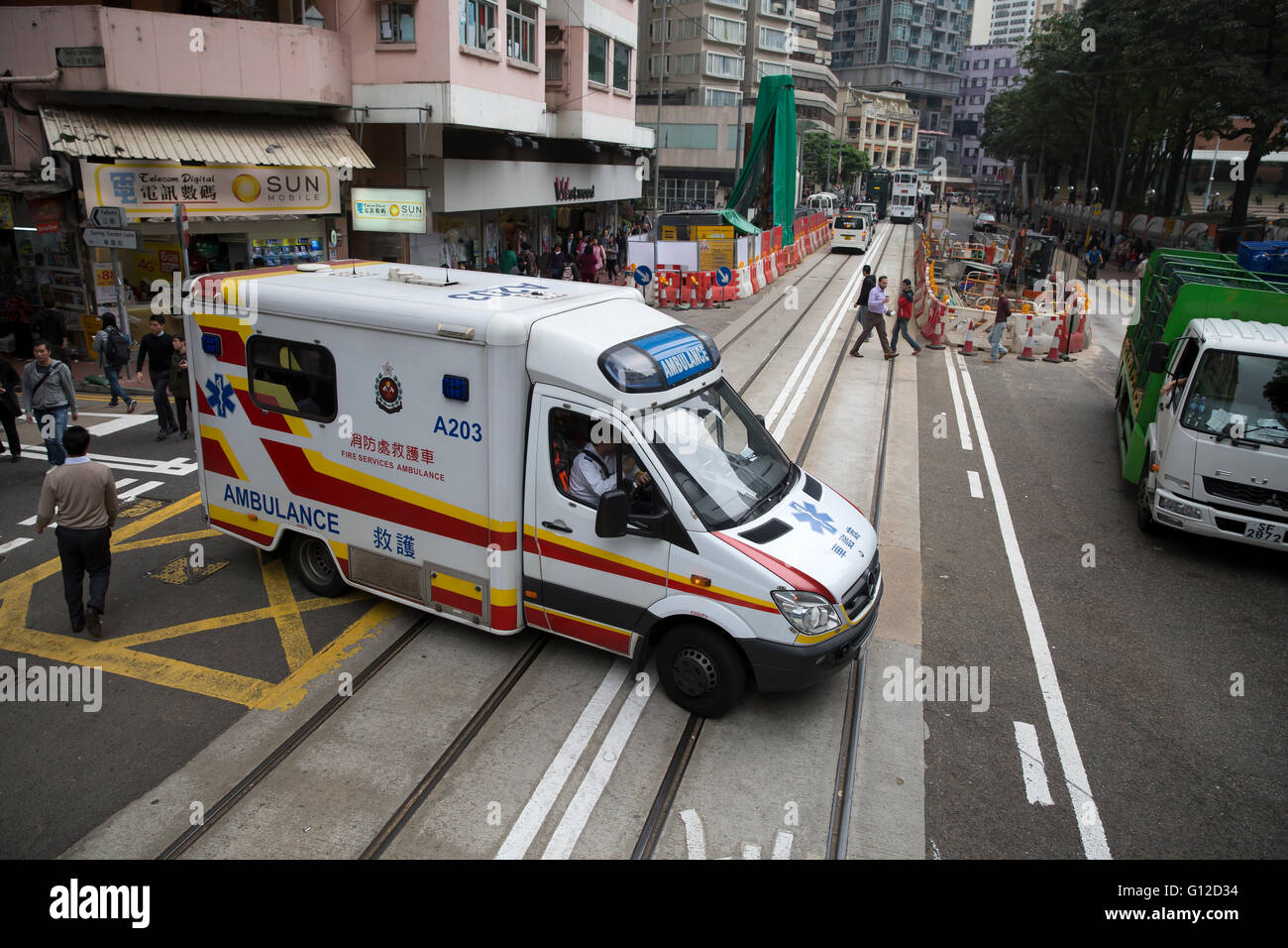 An ambulance drives over the tram lines and through traffic in Hong ...