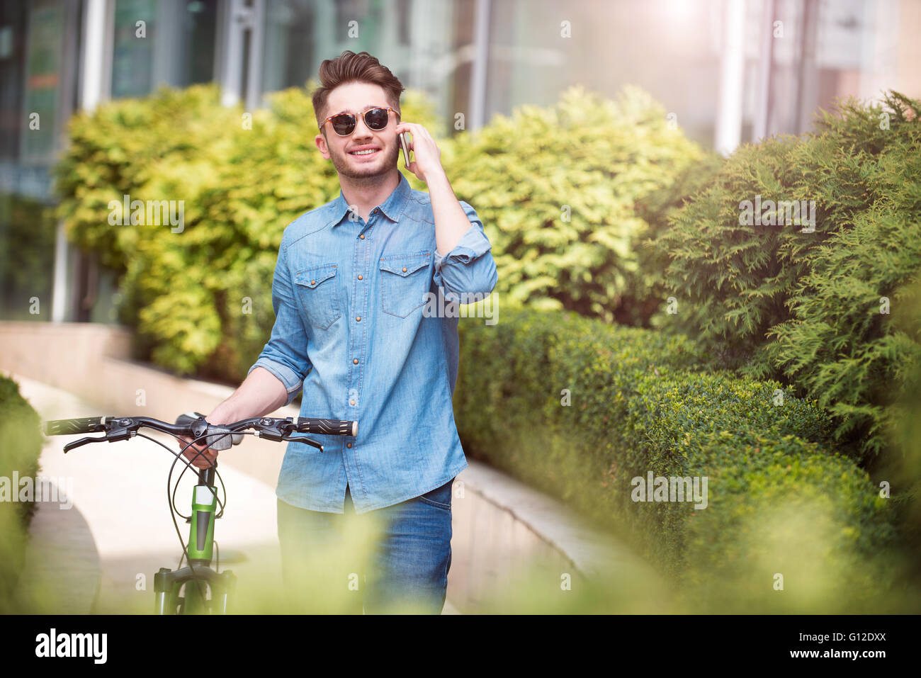 Positive guy riding a bike Stock Photo - Alamy