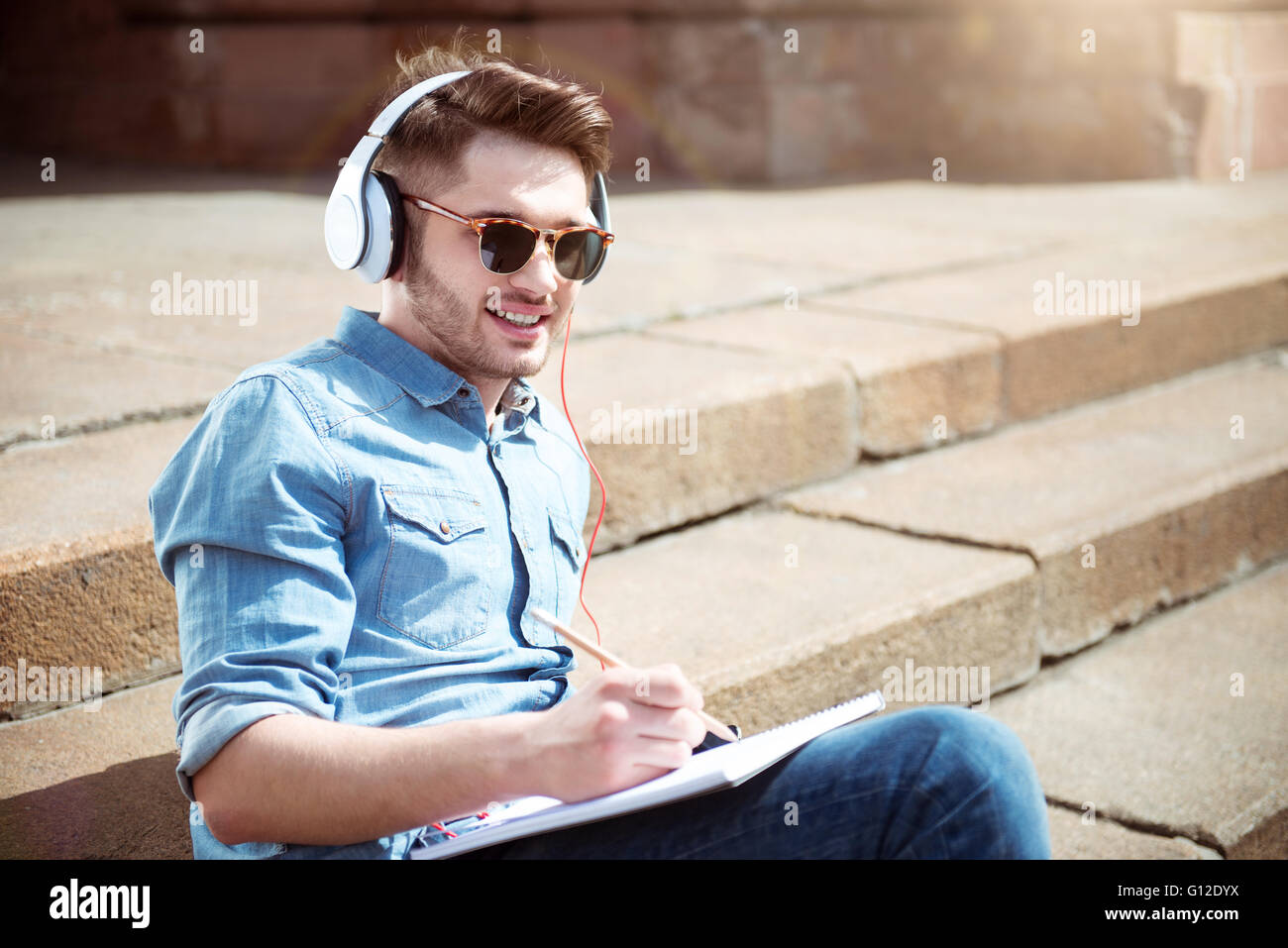Positive guy resting on the footsteps Stock Photo - Alamy