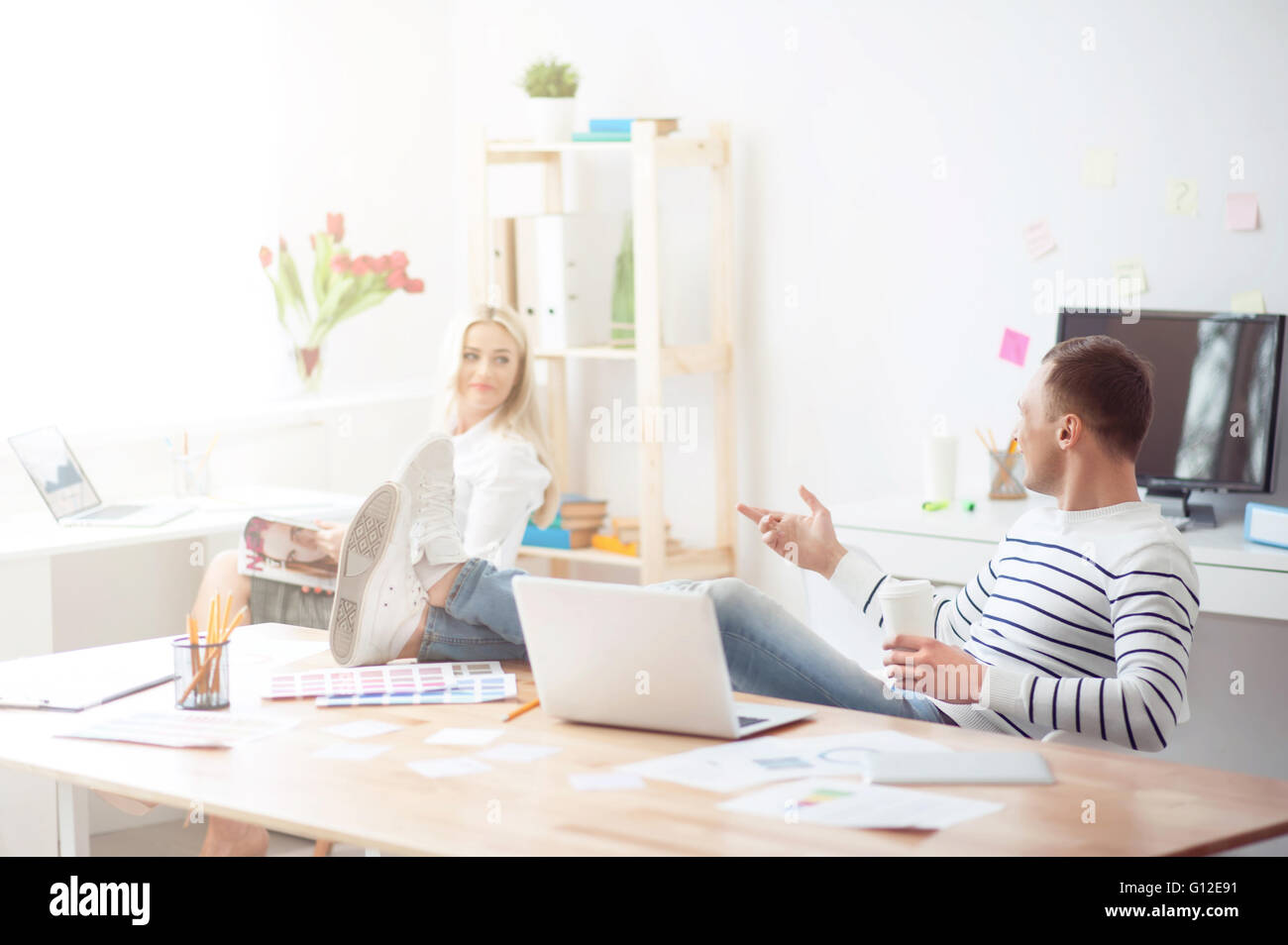 Positive colleagues talking at work Stock Photo - Alamy