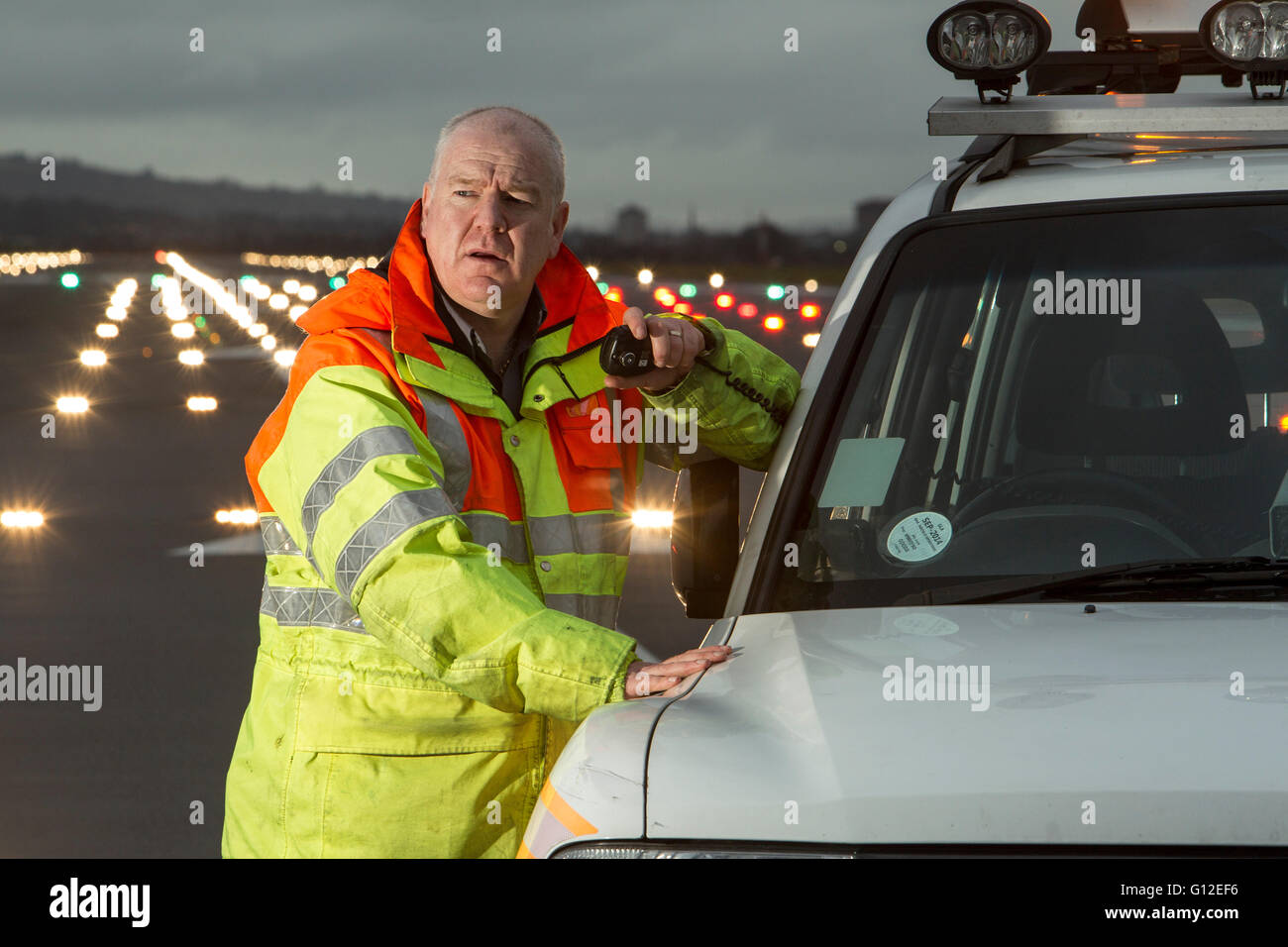 Ground Crew on runway at Glasgow Airport with landing lights in ...