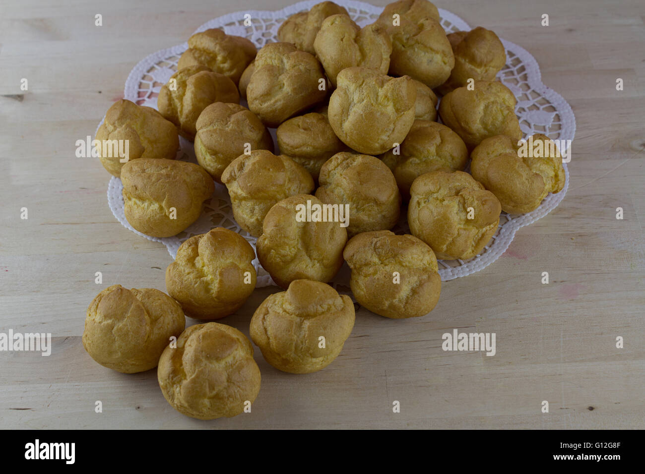 Empty baked Italian bigne to fill in with cream as dessert, on wooden ...