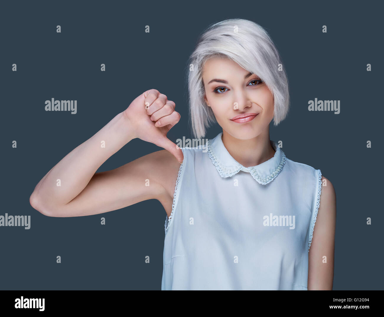 young woman showing her disliking of something with her thumb down ...