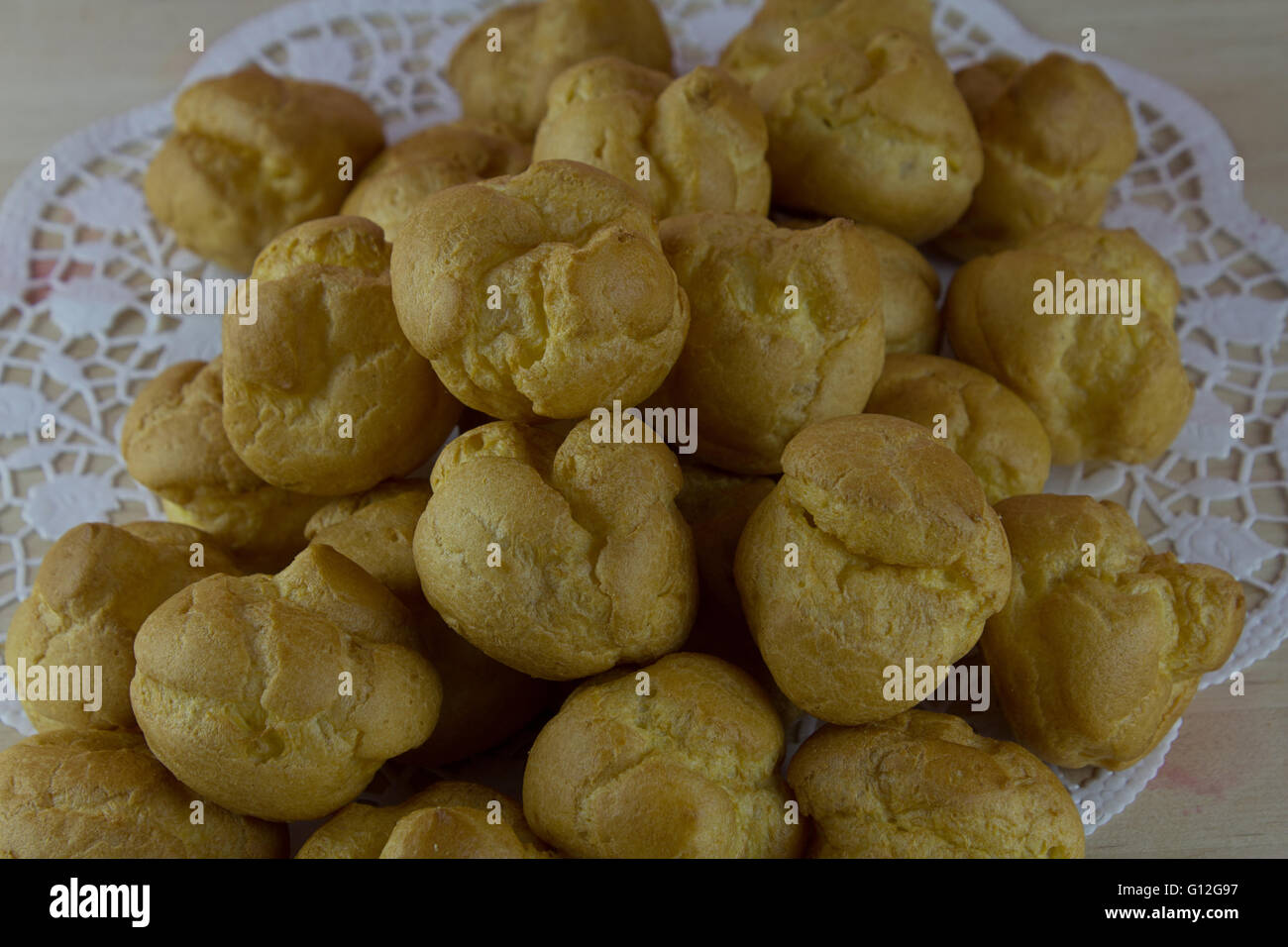 Empty baked Italian bigne to fill in with cream as dessert, on wooden ...