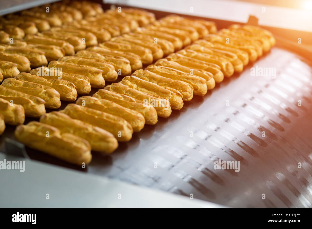 Eclair shells on conveyor line Stock Photo - Alamy