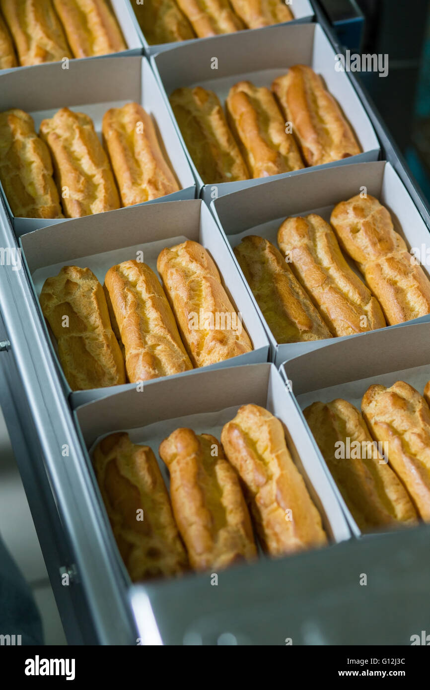 Eclair boxes on conveyor Stock Photo - Alamy