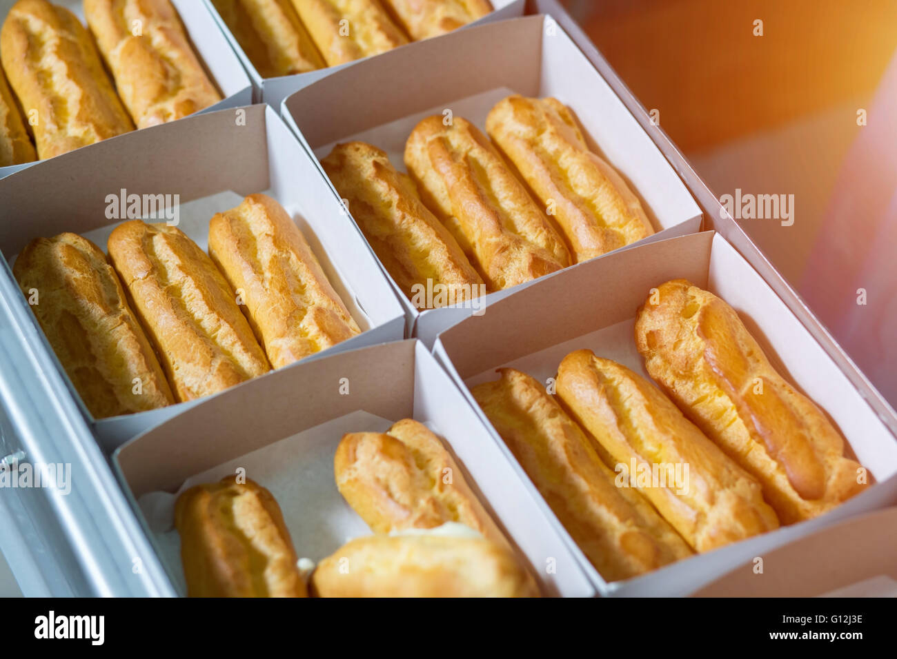 Boxes with eclairs on conveyor Stock Photo - Alamy