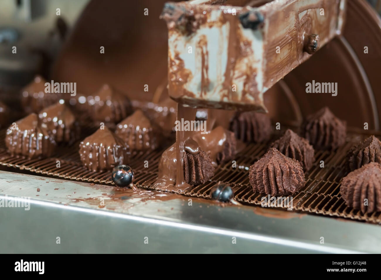 Conveyor pouring liquid onto sweets Stock Photo - Alamy