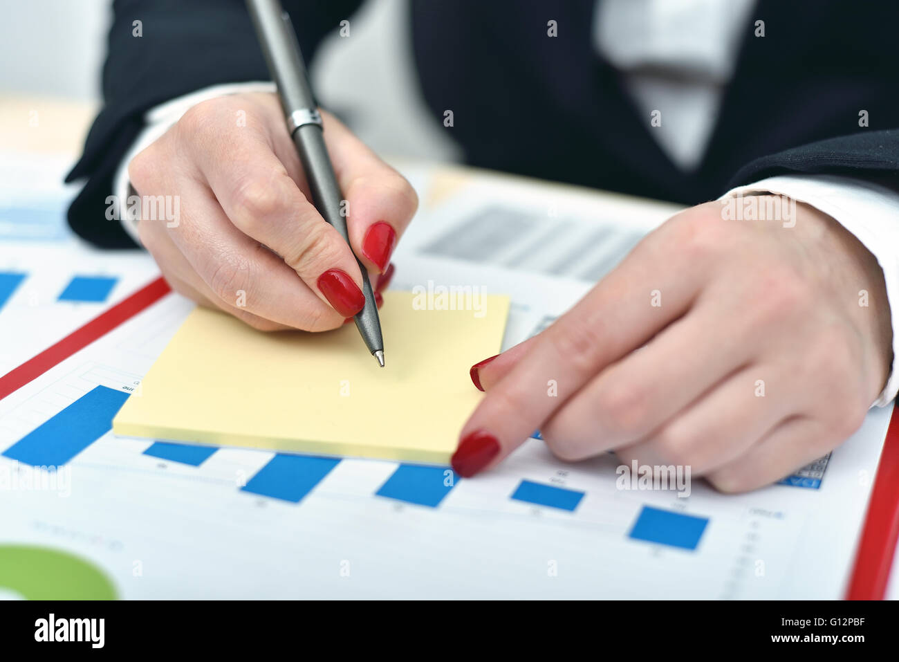 trader woman taking notes on a sheet of paper Stock Photo - Alamy