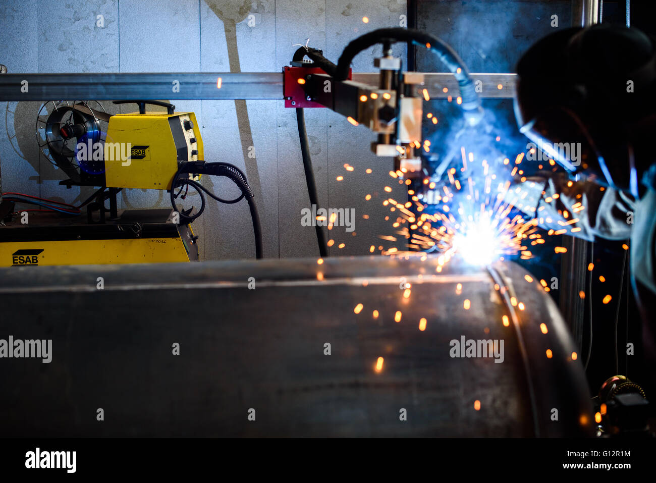 Bright orange sparks during metal grinding in heavy industry plant ...